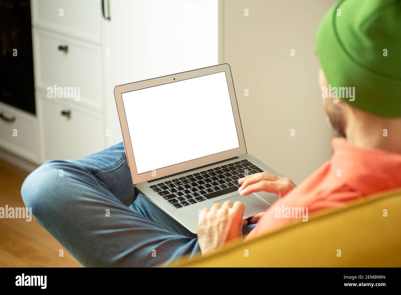 A man works at home with a laptop. Blank laptop screen. Remote work ...