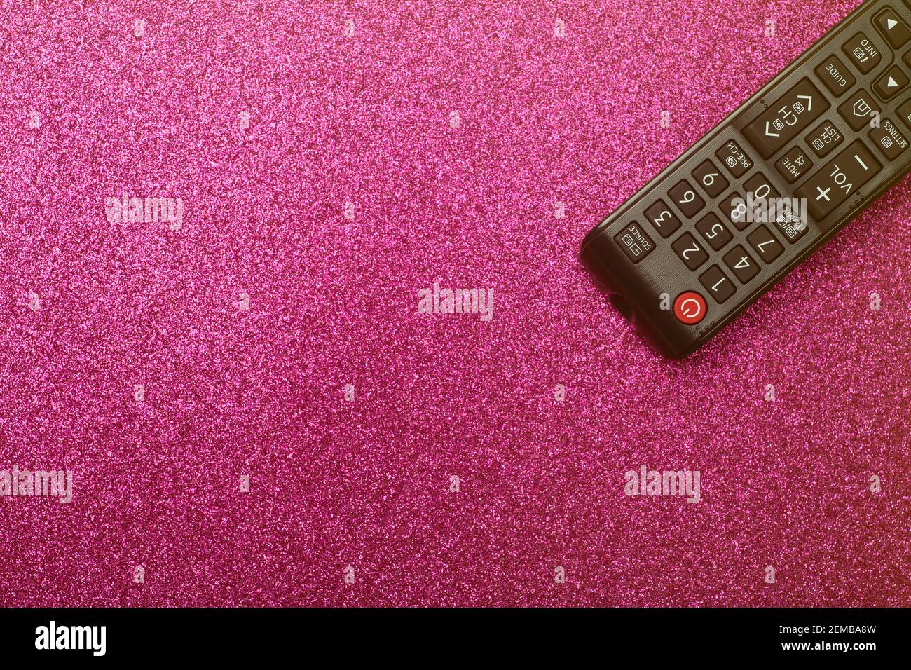 Tv remote in on a pink glitter glamor background. Cinema, entertainment ...