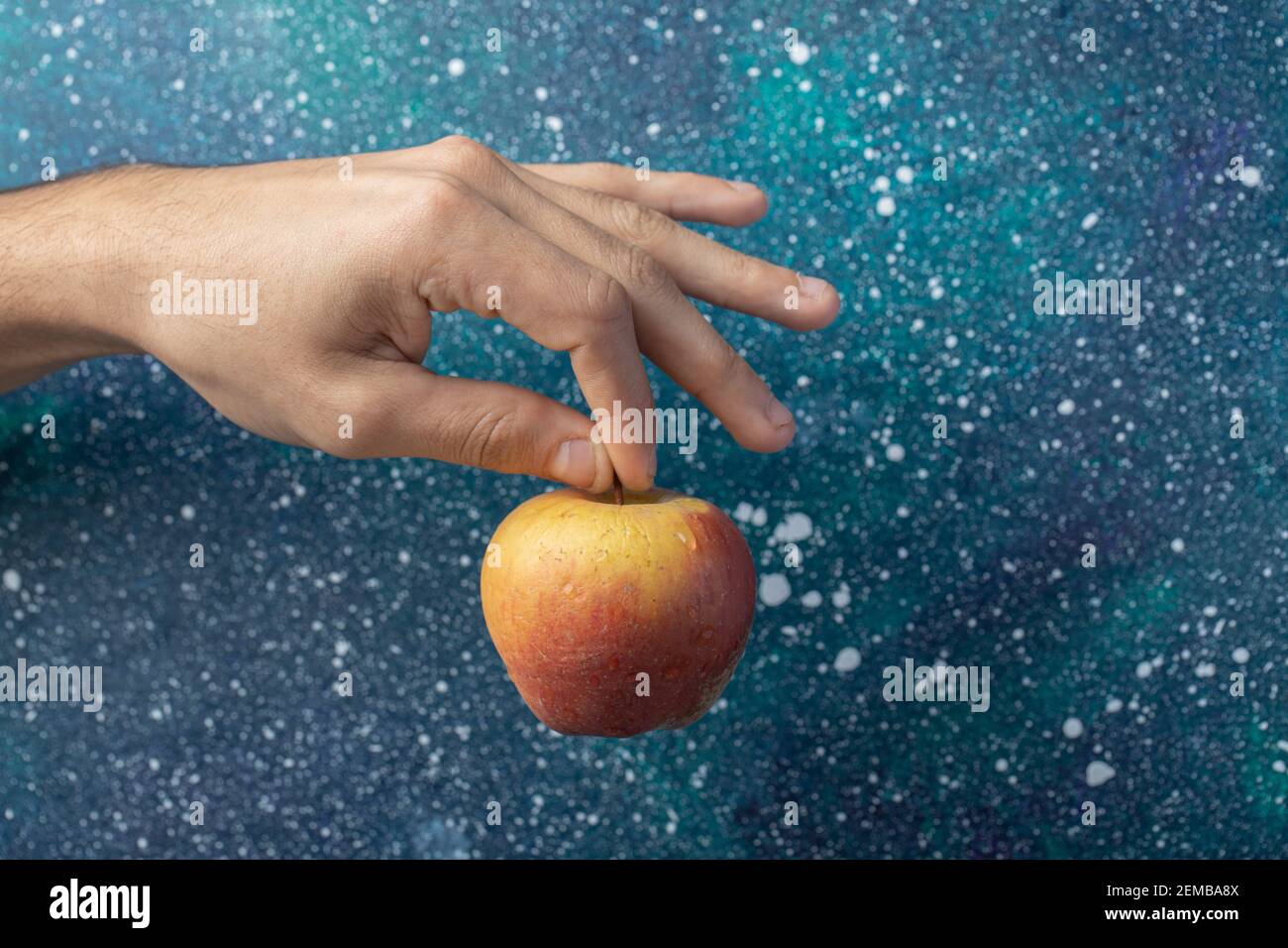 Man hand holding a whole red apple Stock Photo - Alamy