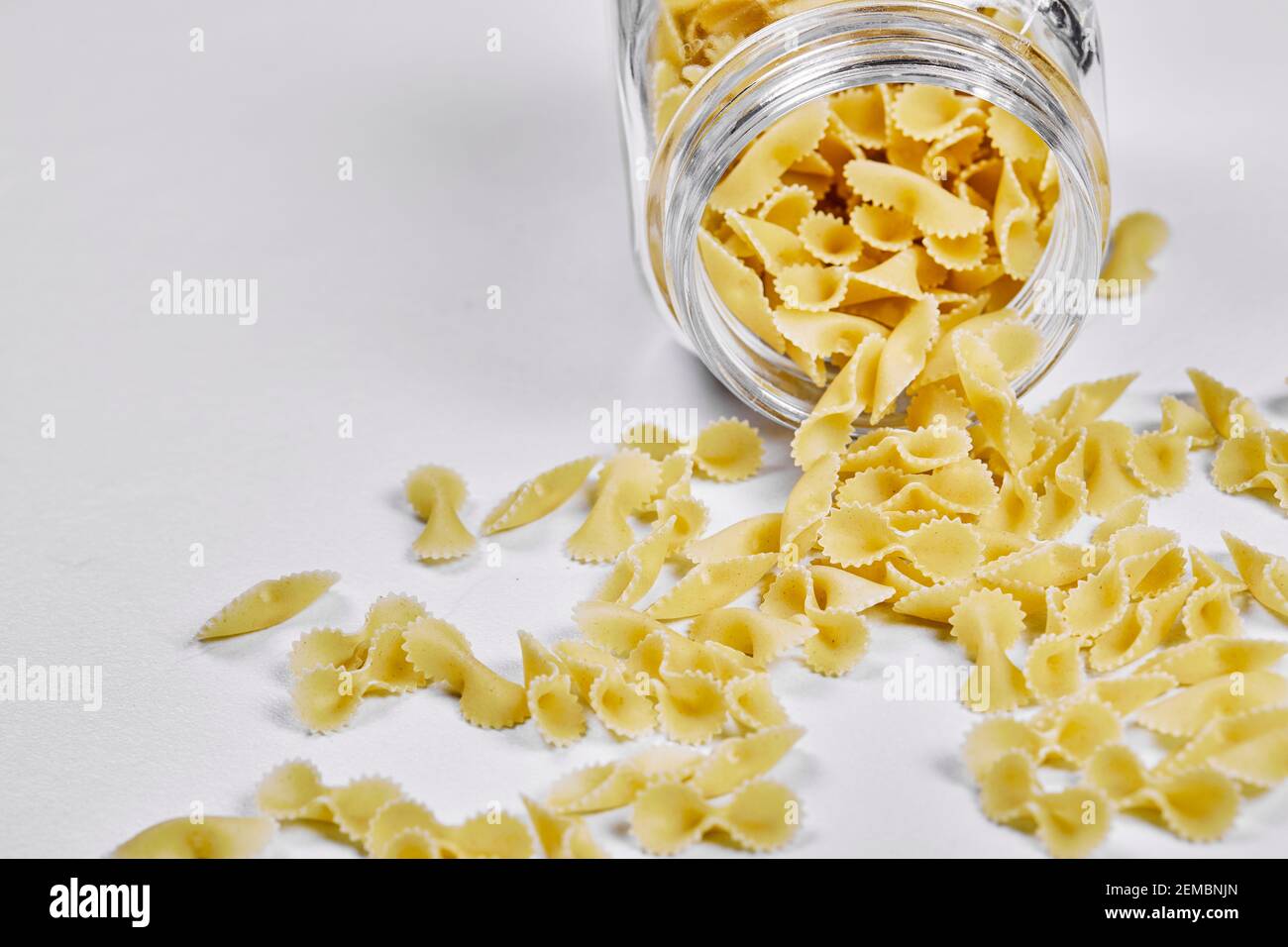 Raw pasta inside the glass jar on white background Stock Photo - Alamy