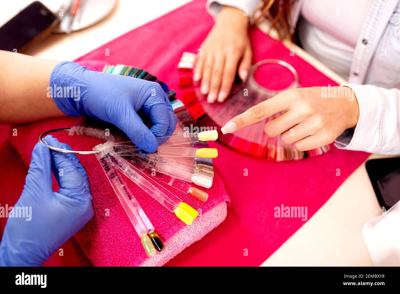 Nail color palette and curious fingers, manicure salon Stock Photo - Alamy