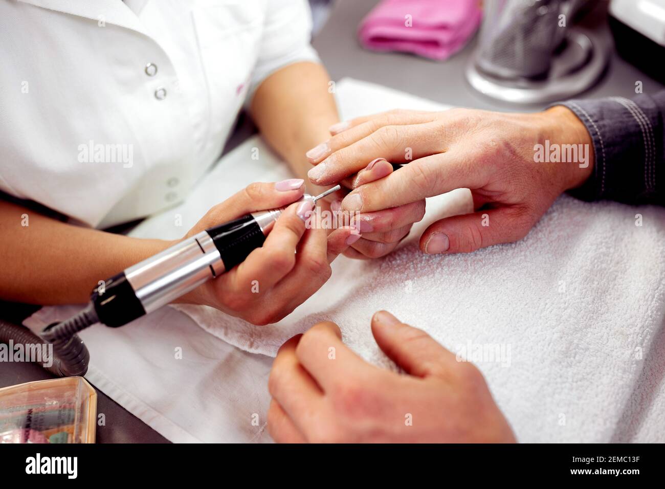 Manicurist using electric nail file on the nails of her customer, neat ...