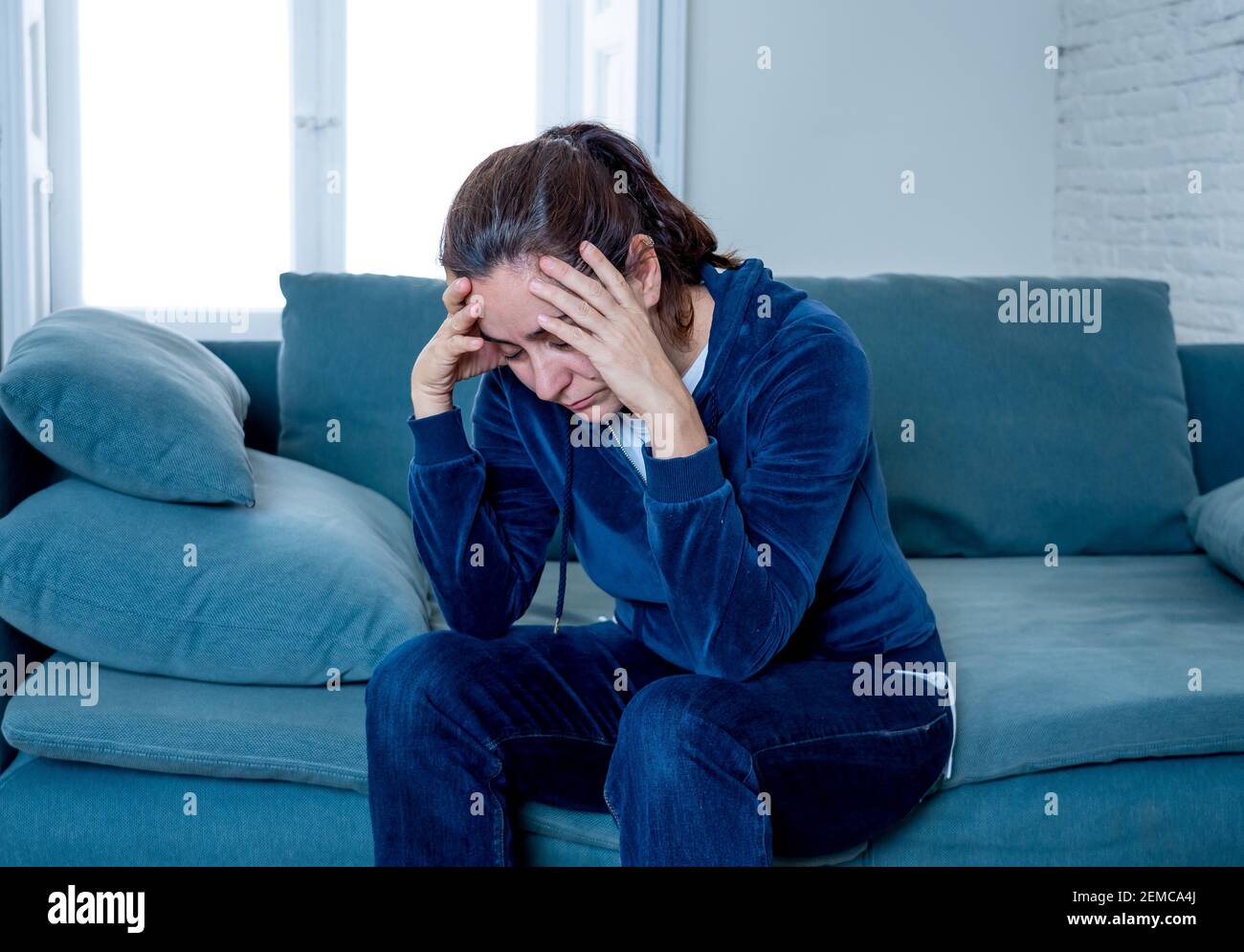 Young lonely attractive latin woman crying on couch feeling sad tired ...