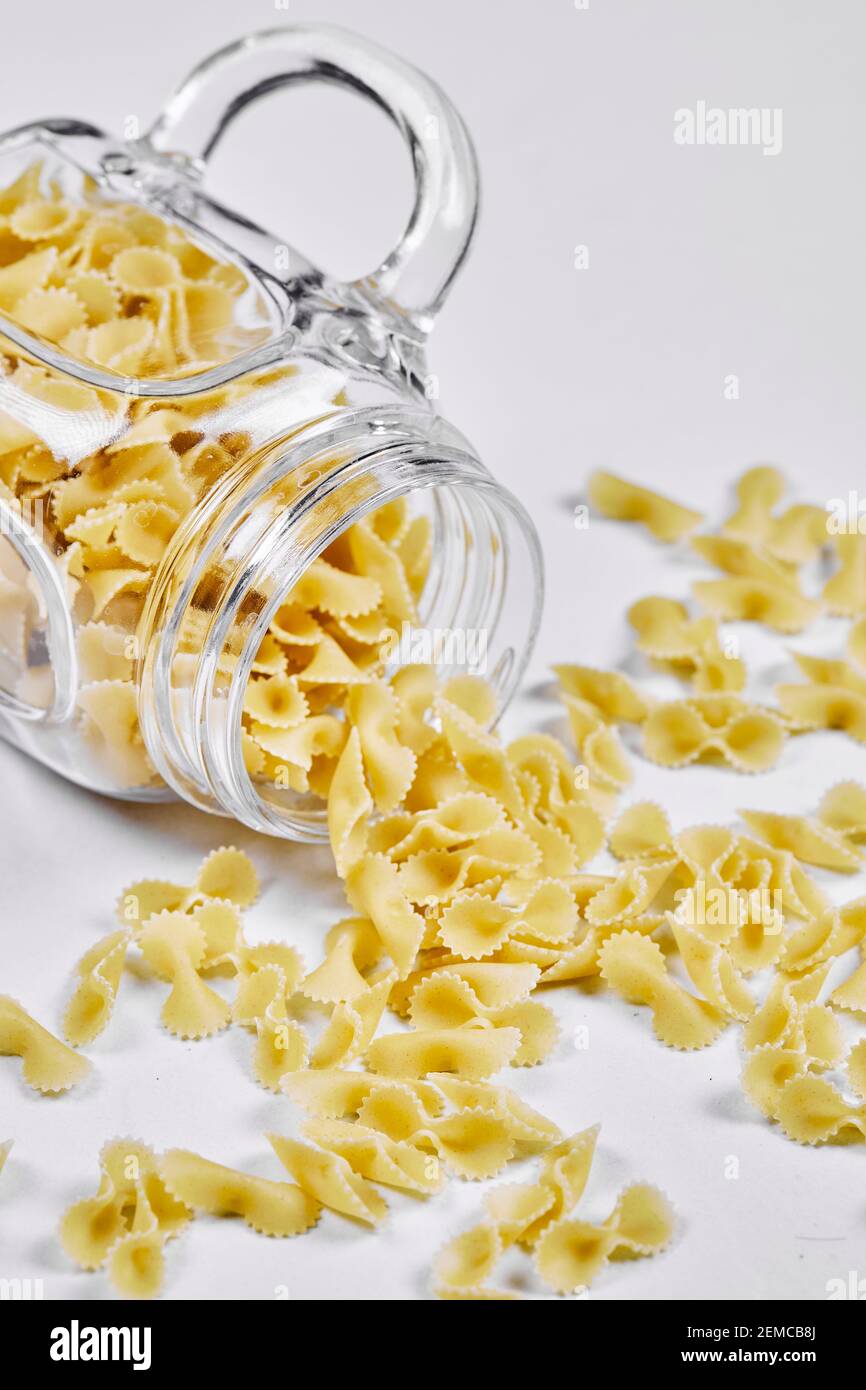 Raw pasta inside the glass jar on white background Stock Photo - Alamy