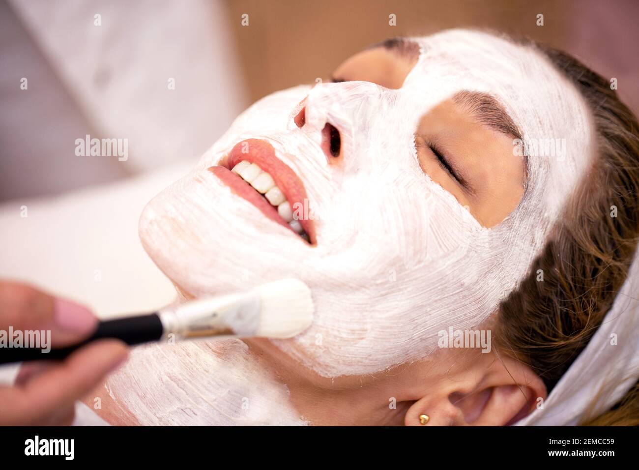 Beauty skin layer mask being applied on a woman’s face with a brush ...