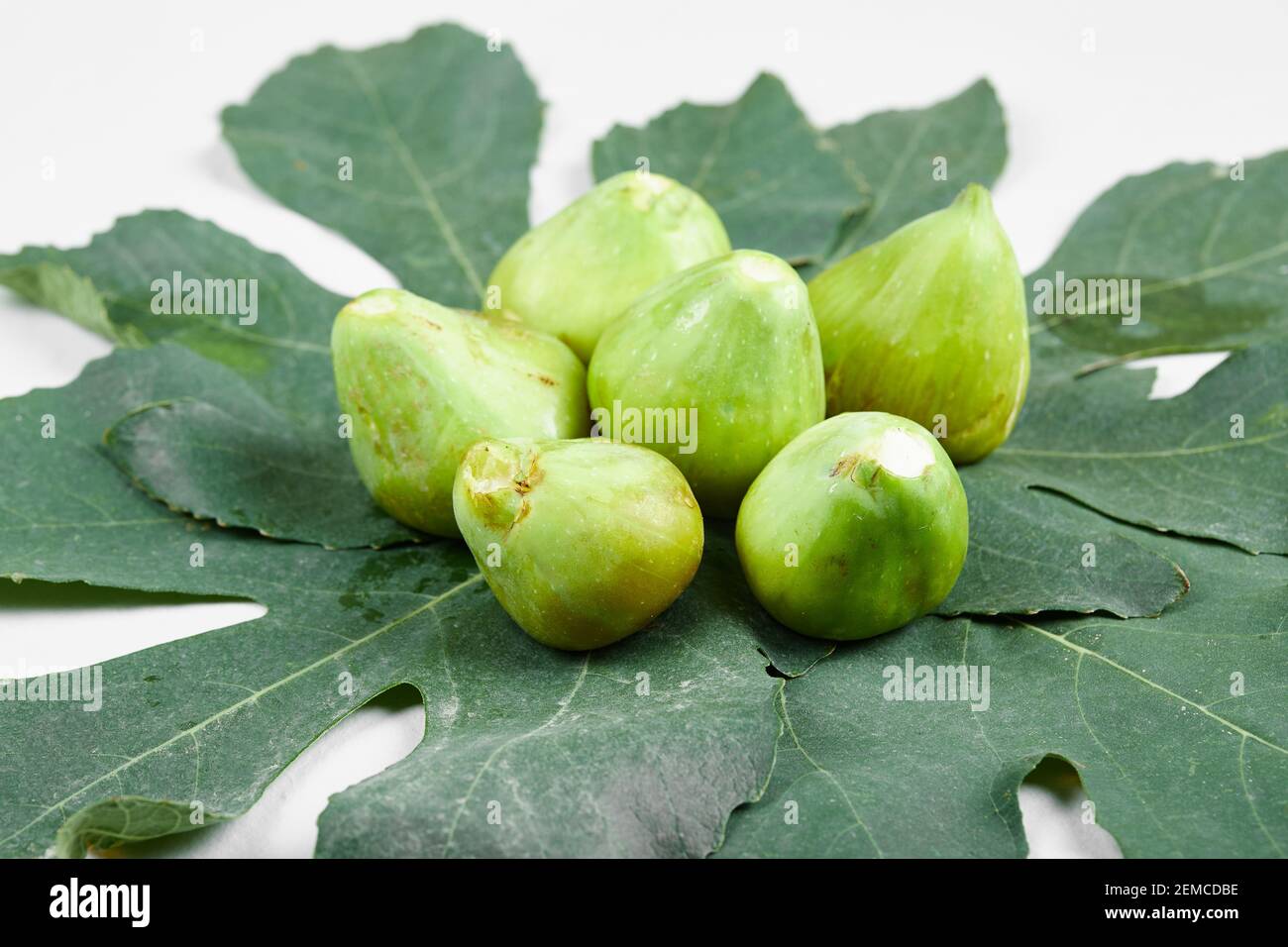 Ripe green figs with leaves on white background Stock Photo - Alamy