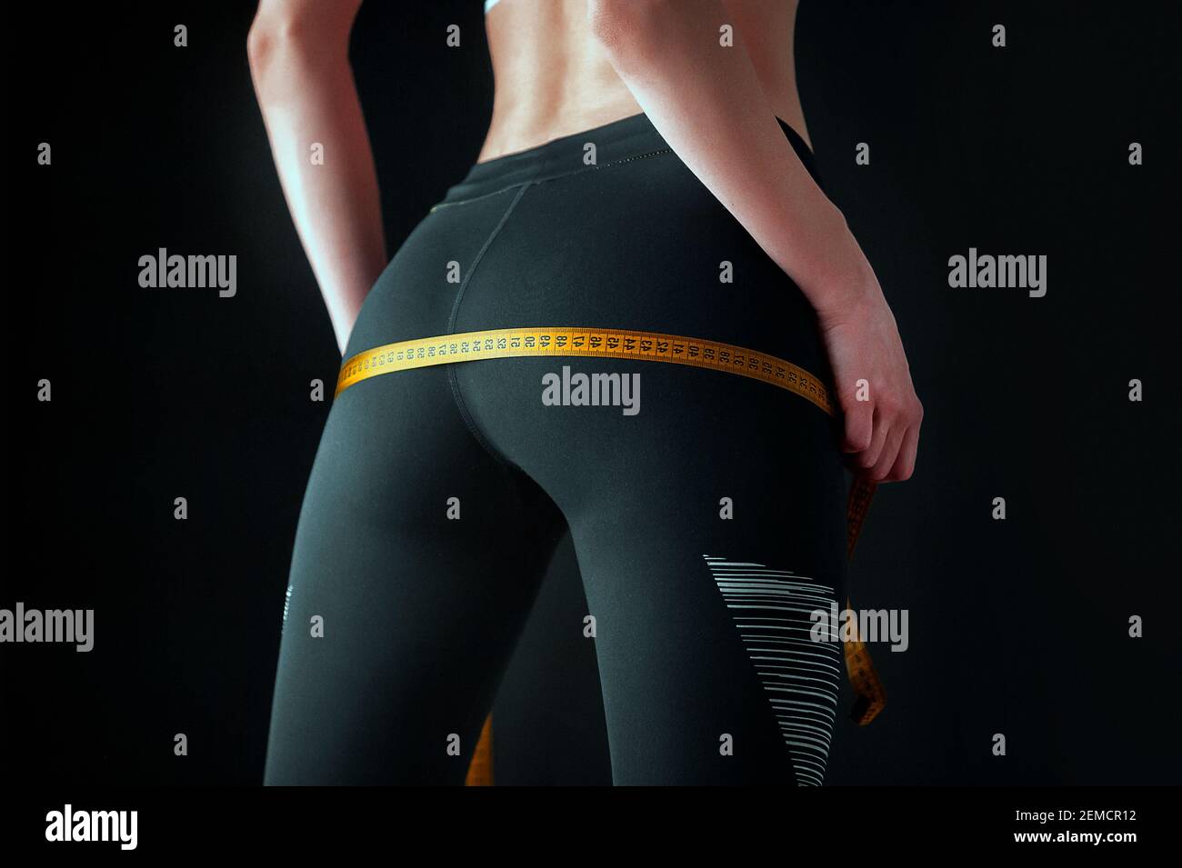 girl with perfect sports figure measures the size of their buttocks ...