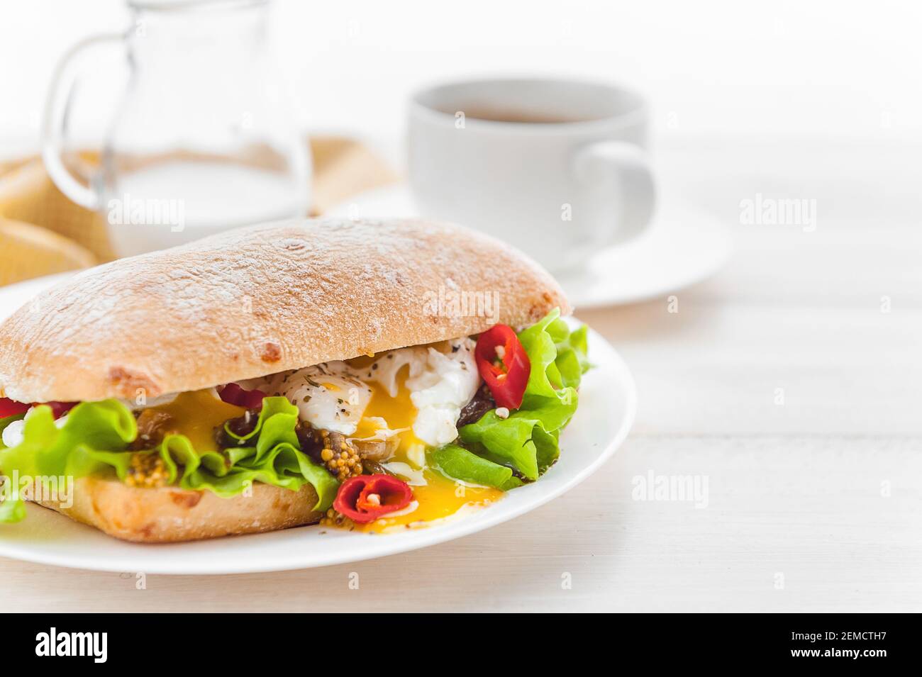 breakfast in a rustic style on a white wooden surface. ciabatta with ...