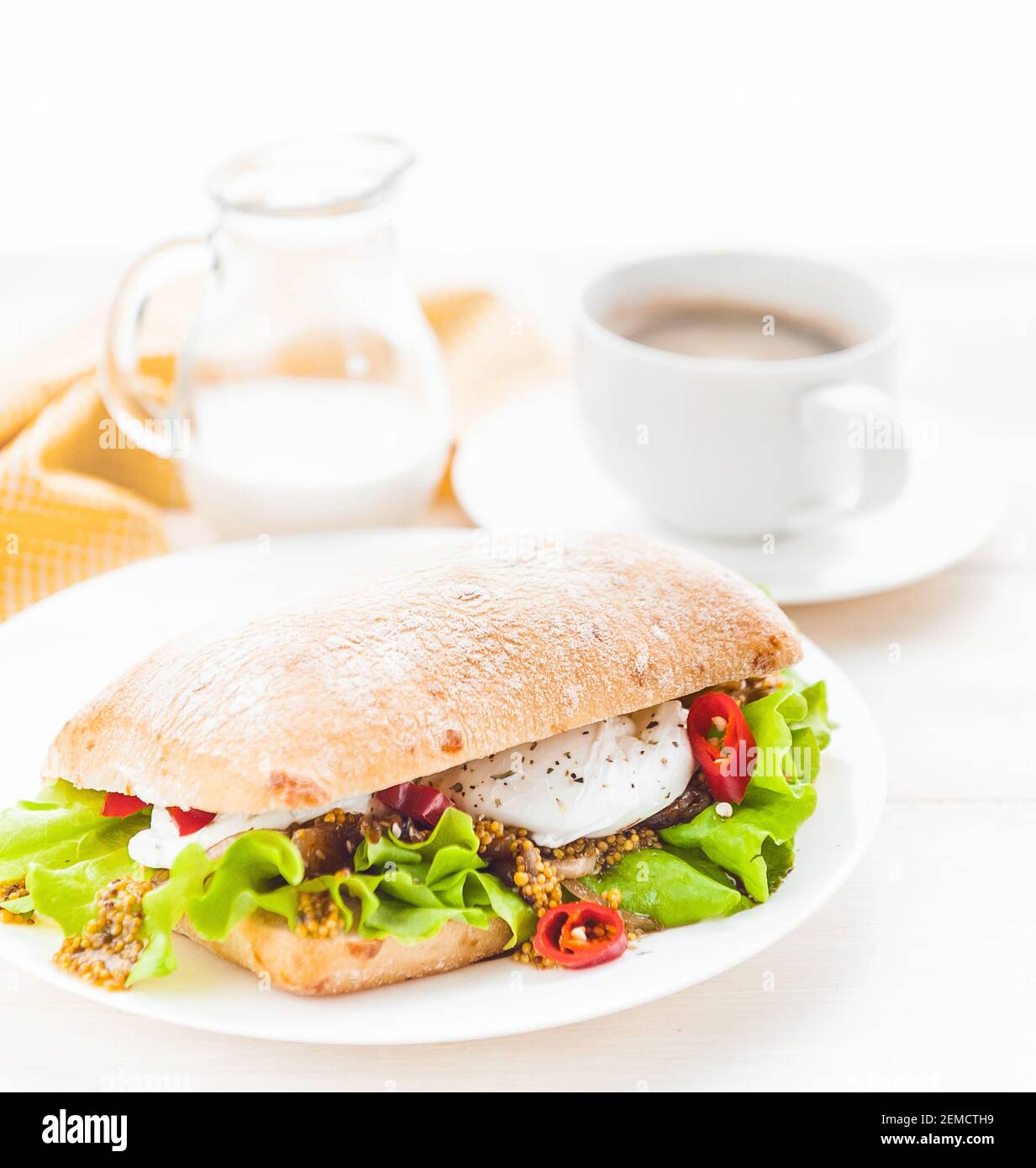 breakfast in a rustic style on a white wooden surface. ciabatta with ...
