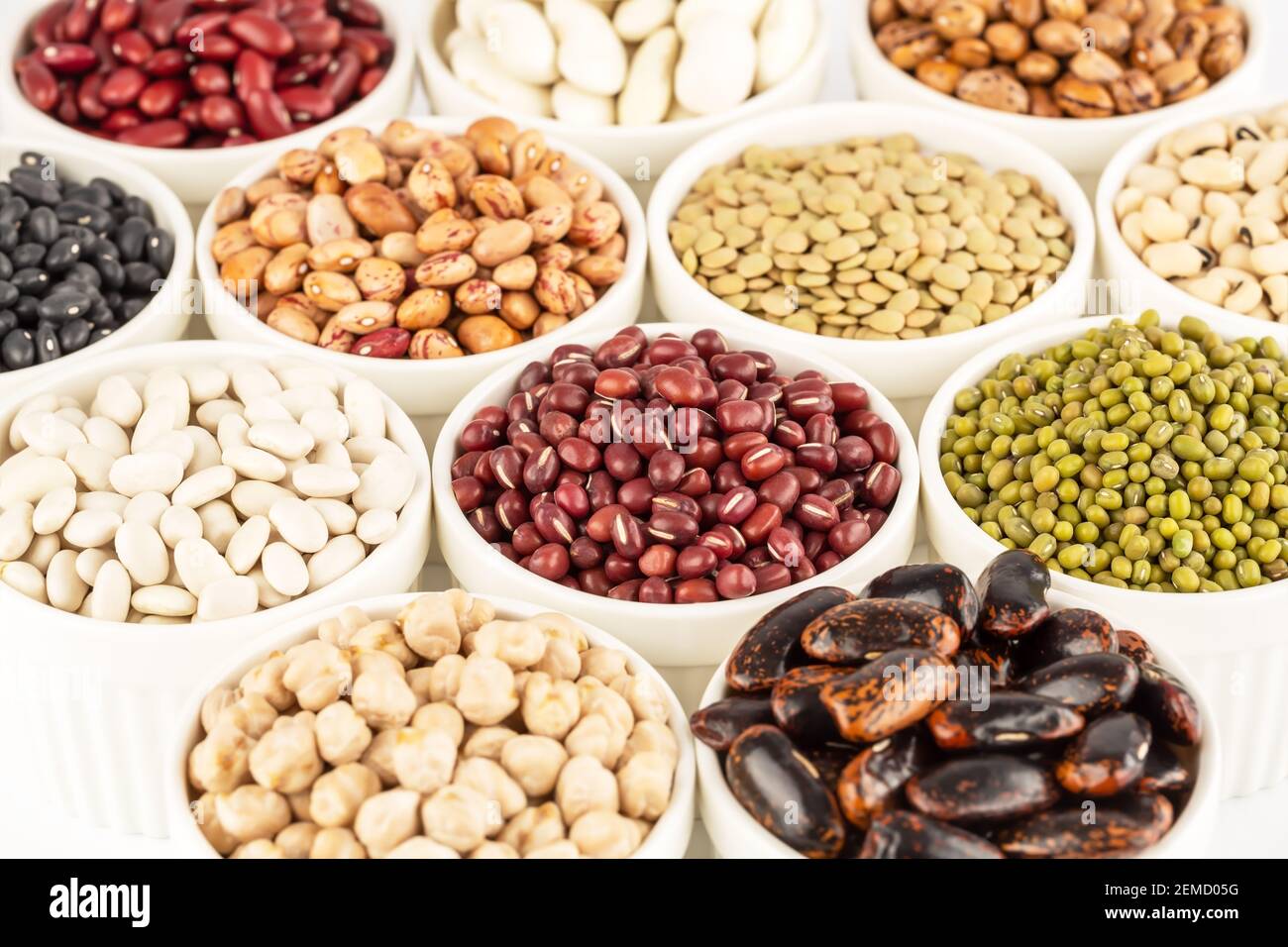 The collection of different beans and lentils in the ceramic bowls ...