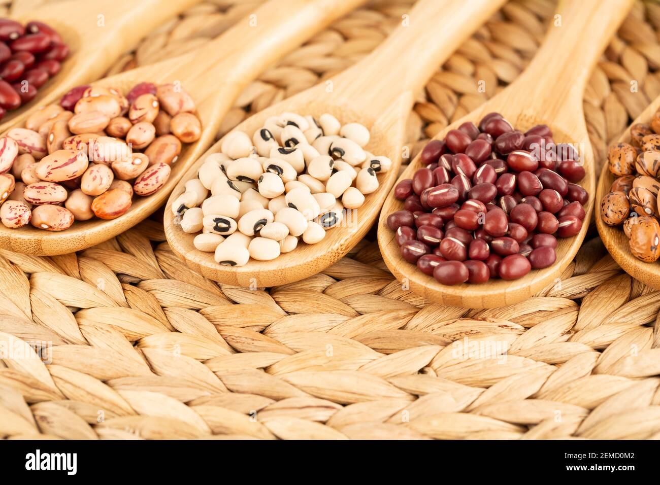 Various beans in the wooden spoons on the beige background Stock Photo ...