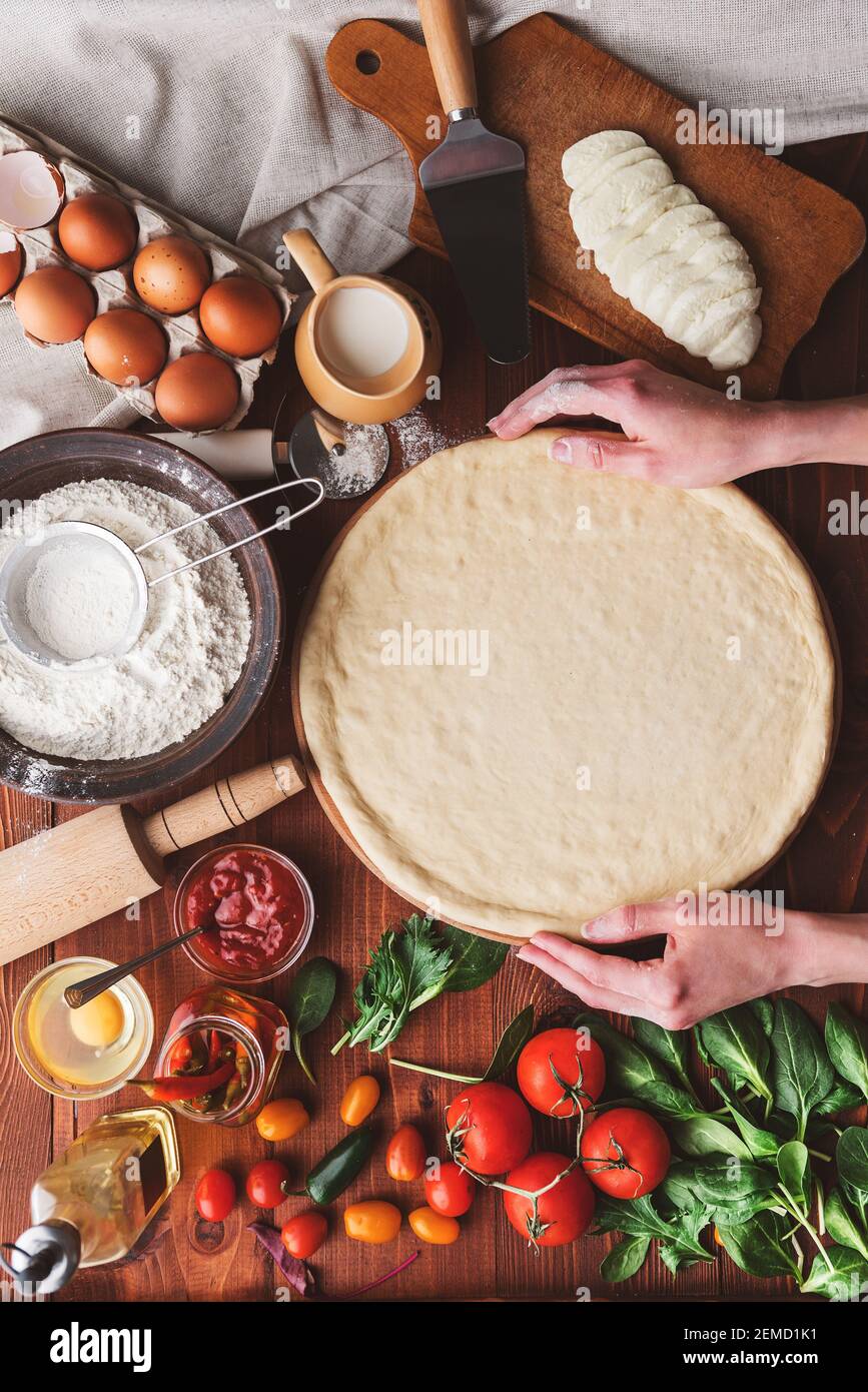 Step-by-step boss makes a pizza margarita. Dough and pizza ingredients ...