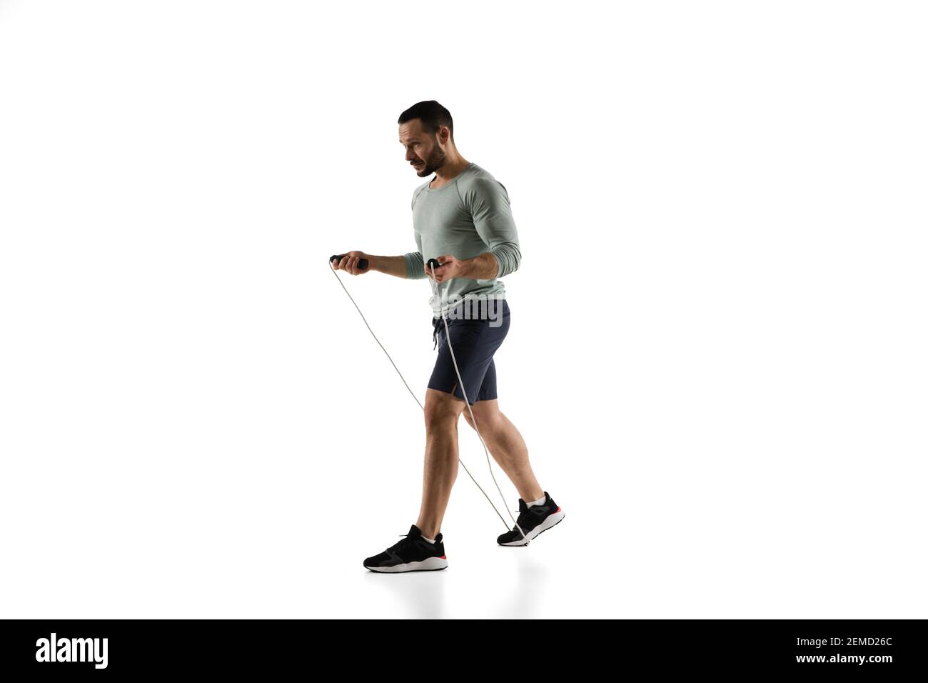 Jumping-rope. Young caucasian male model in action, motion on white ...