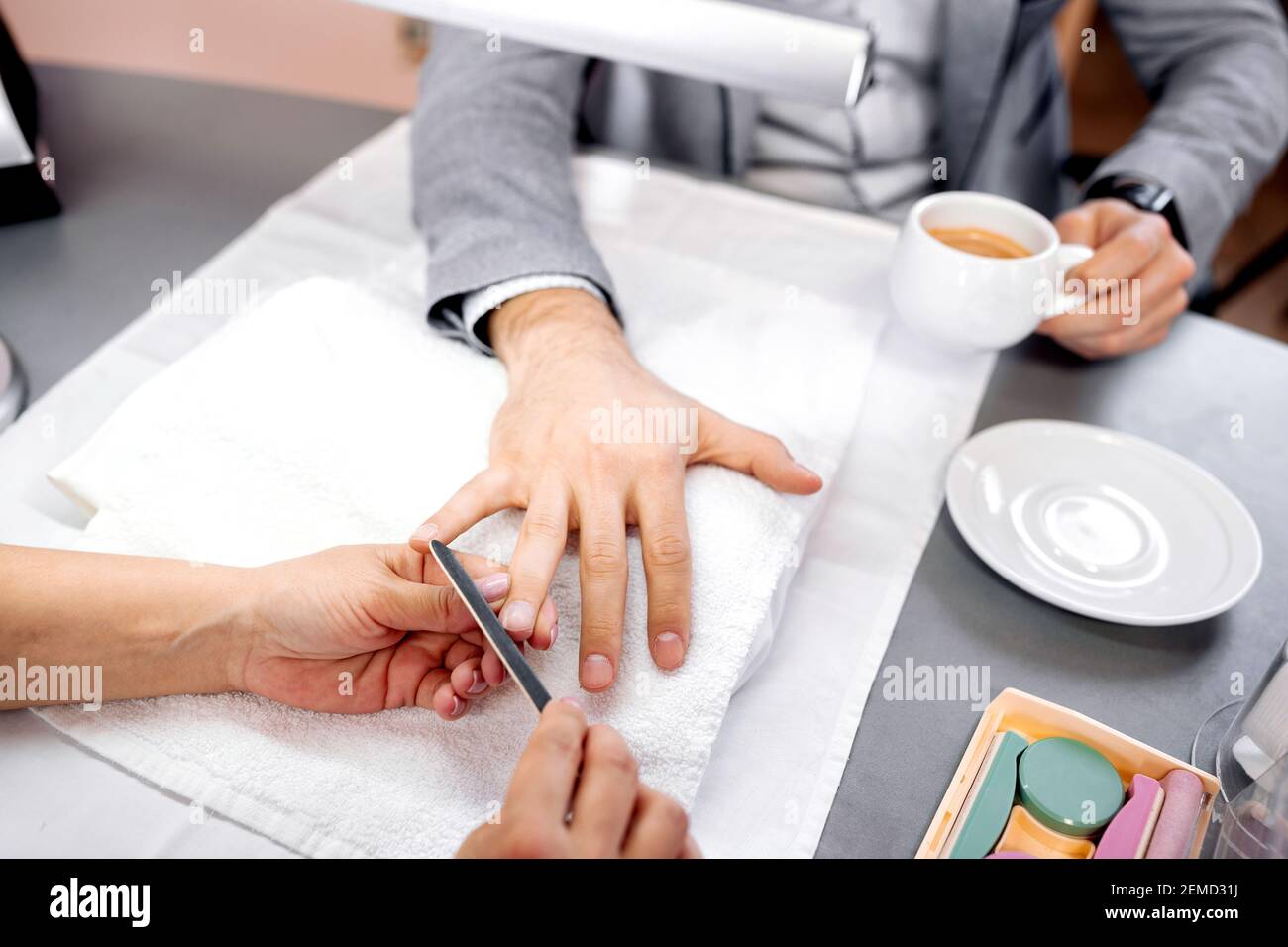 Trimming And Smoothing The Edges Of Nails On A Young Mans Hand