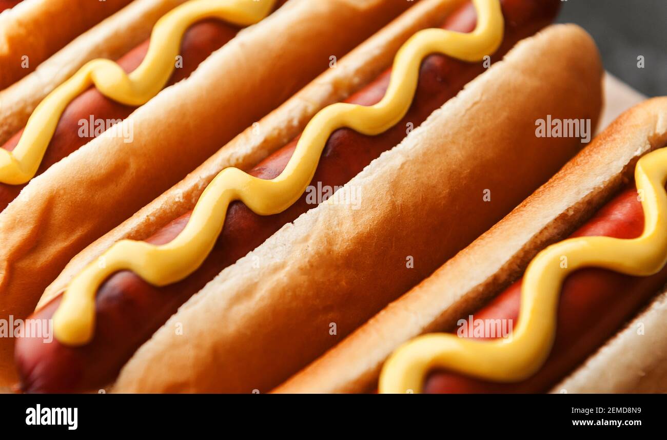 Barbecue Grilled Hot Dogs with yellow American mustard, On a dark ...