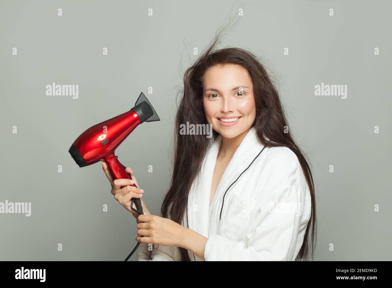 Pretty young model woman with hair dryer on white background. Female ...