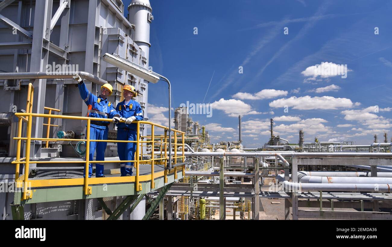 teamwork: group of industrial workers in a refinery - oil processing ...