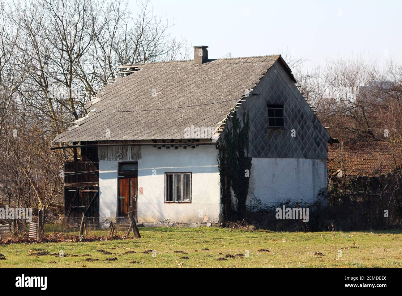 Destroyed abandoned small old wooden family house with broken roof ...