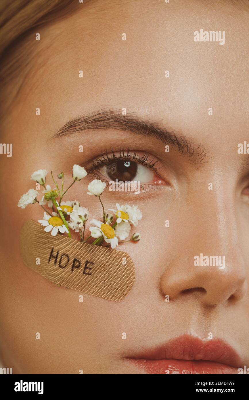 Hope concept. Closeup female face with flowers and hope inscription ...
