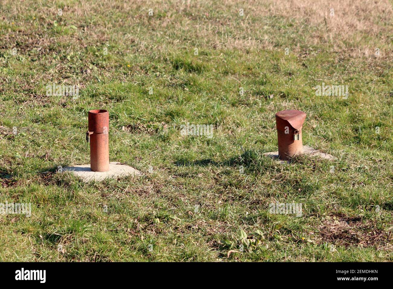 Two old rusted industrial metal pipes with broken padlock locked caps ...