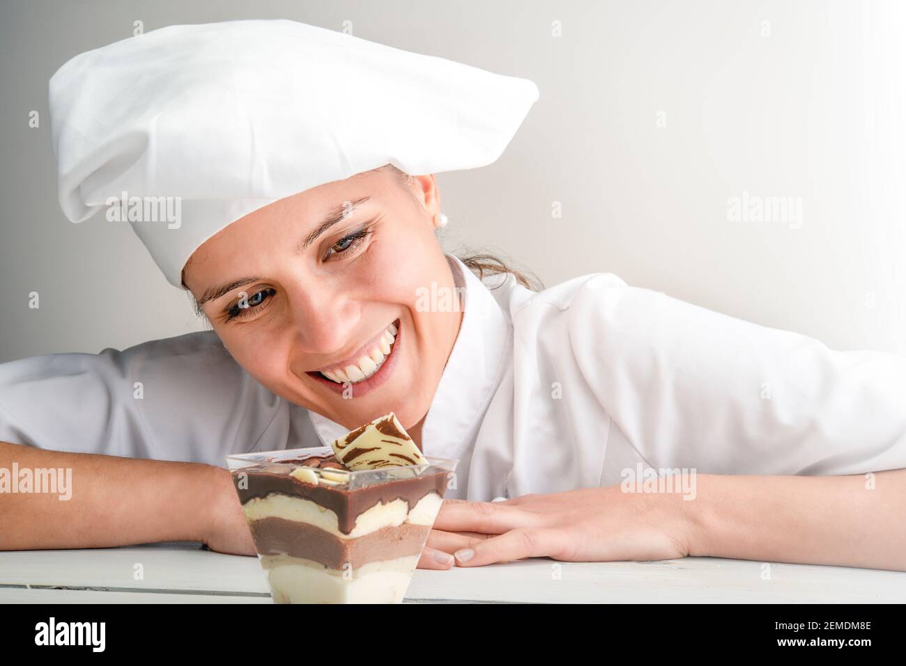 woman pastry chef smiling while observing tiramisu, a typical sweet of ...