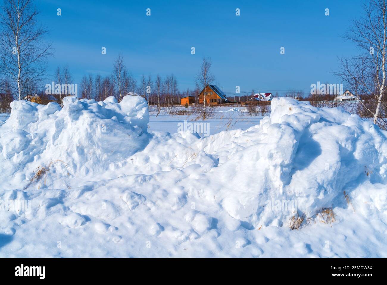 Huge piles of snow after the work of a tractor to clear rural roads in ...