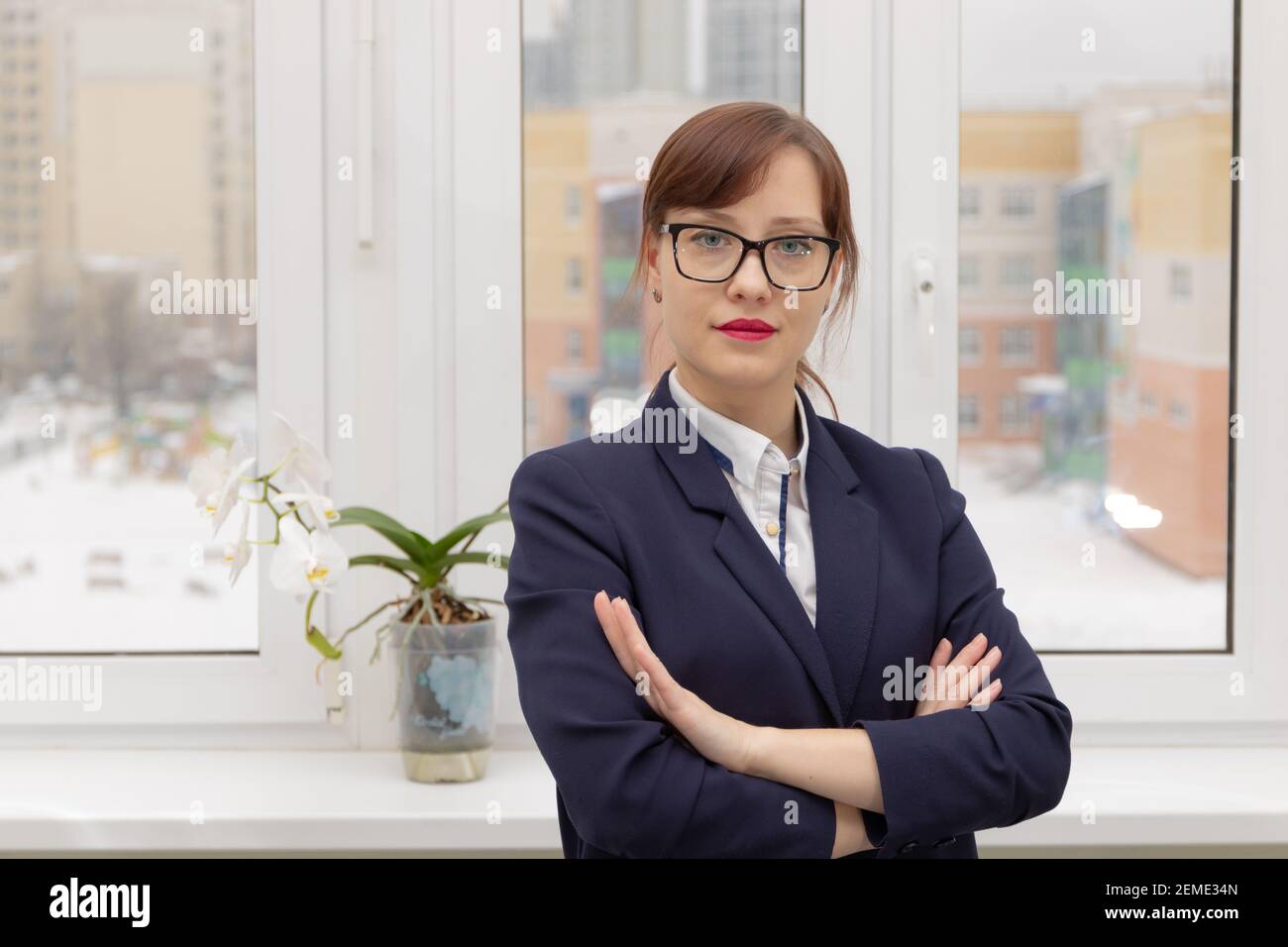 young strict business woman in a blue jacket and glasses is thinking at ...