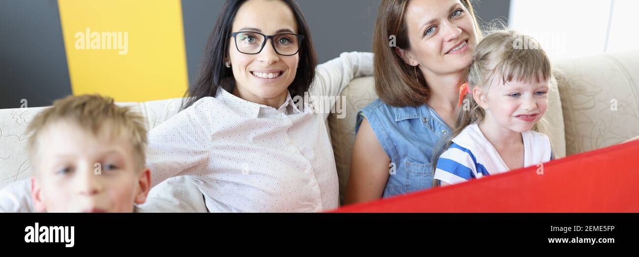 Two women, boy and a girl are sitting on top of LGBT flag Stock Photo ...