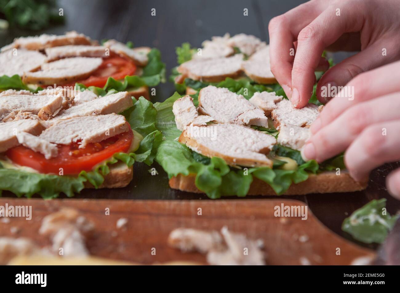 girl chef making sandwich in rustic style with turkey meat and chicken ...