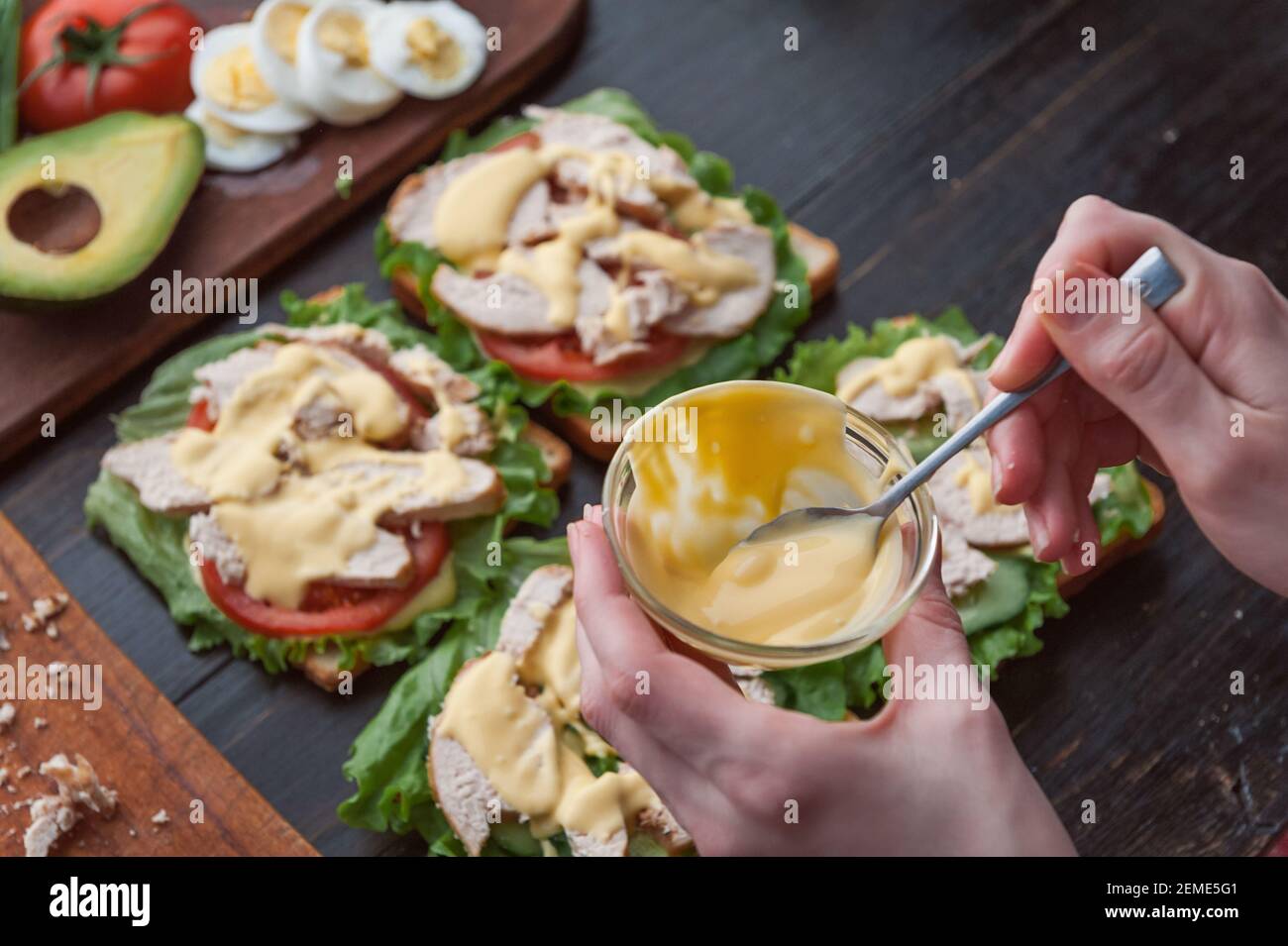 girl chef making sandwich in rustic style with turkey meat and chicken ...