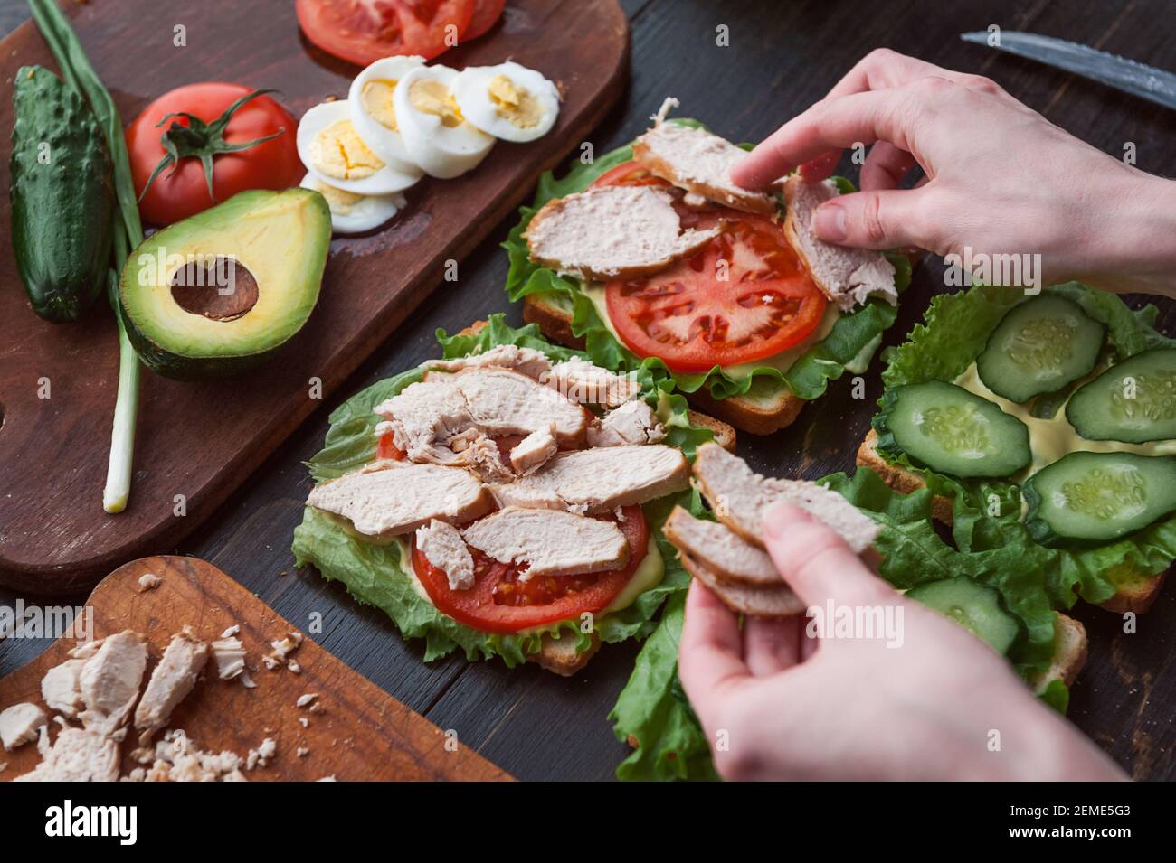 girl chef making sandwich in rustic style with turkey meat and chicken ...