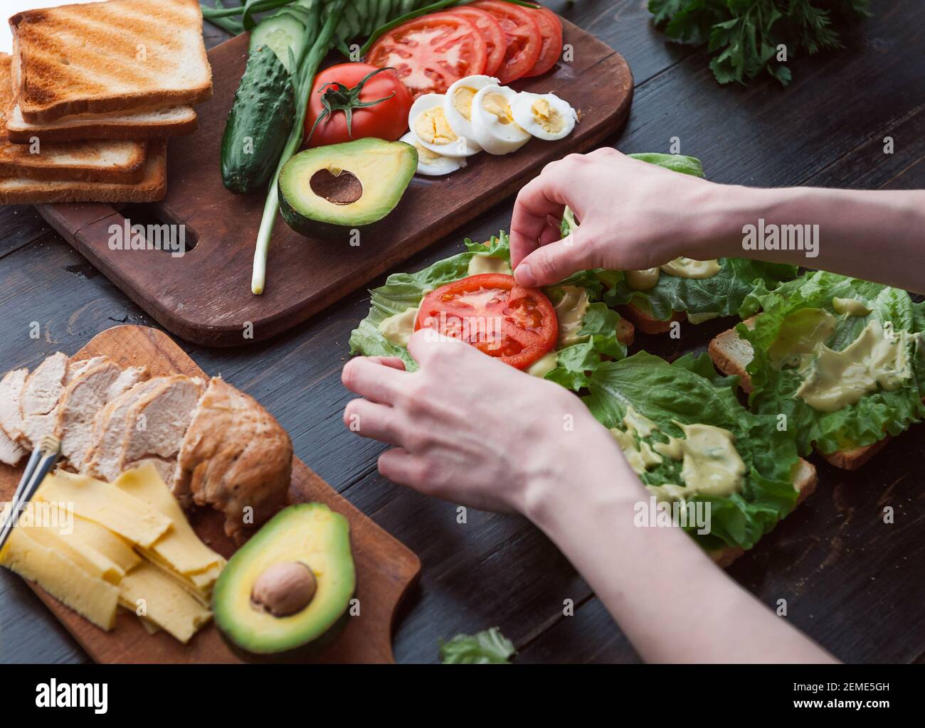 girl chef making sandwich in rustic style with turkey meat and chicken ...
