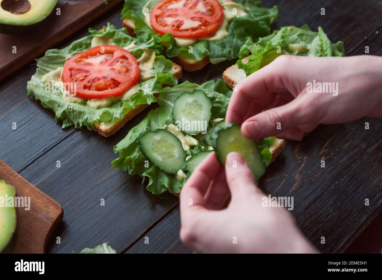 girl chef making sandwich in rustic style with turkey meat and chicken ...
