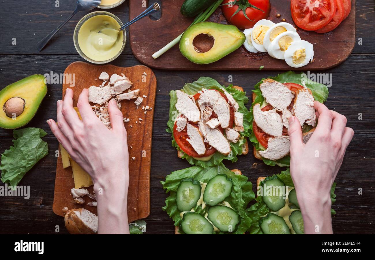 girl chef making sandwich in rustic style with turkey meat and chicken ...