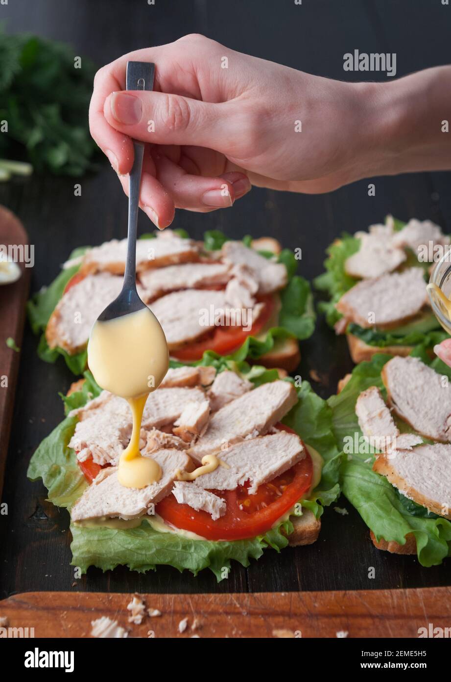 girl chef making sandwich in rustic style with turkey meat and chicken ...