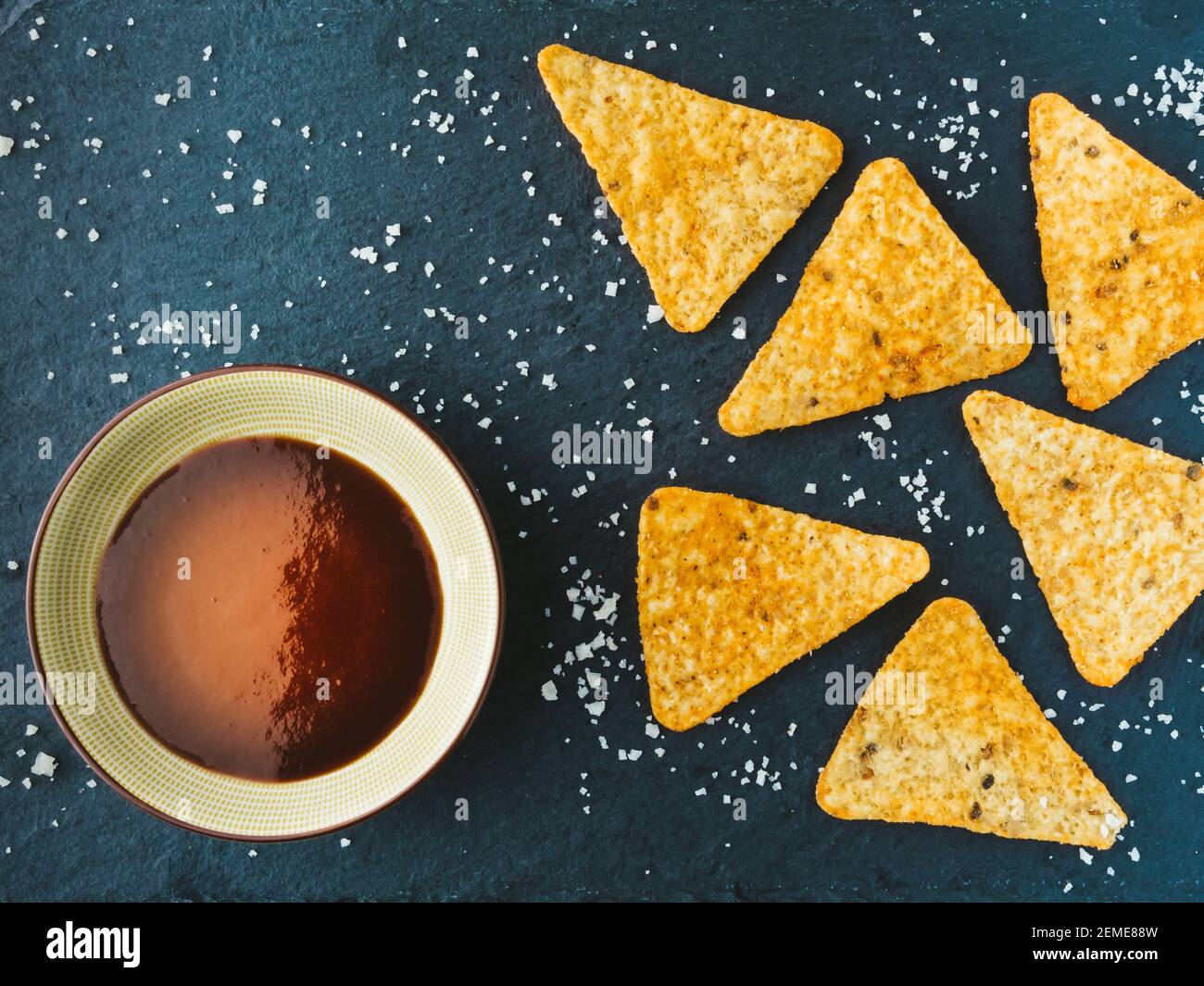 food background. Yellow triangle shaped tortilla chips on black ...
