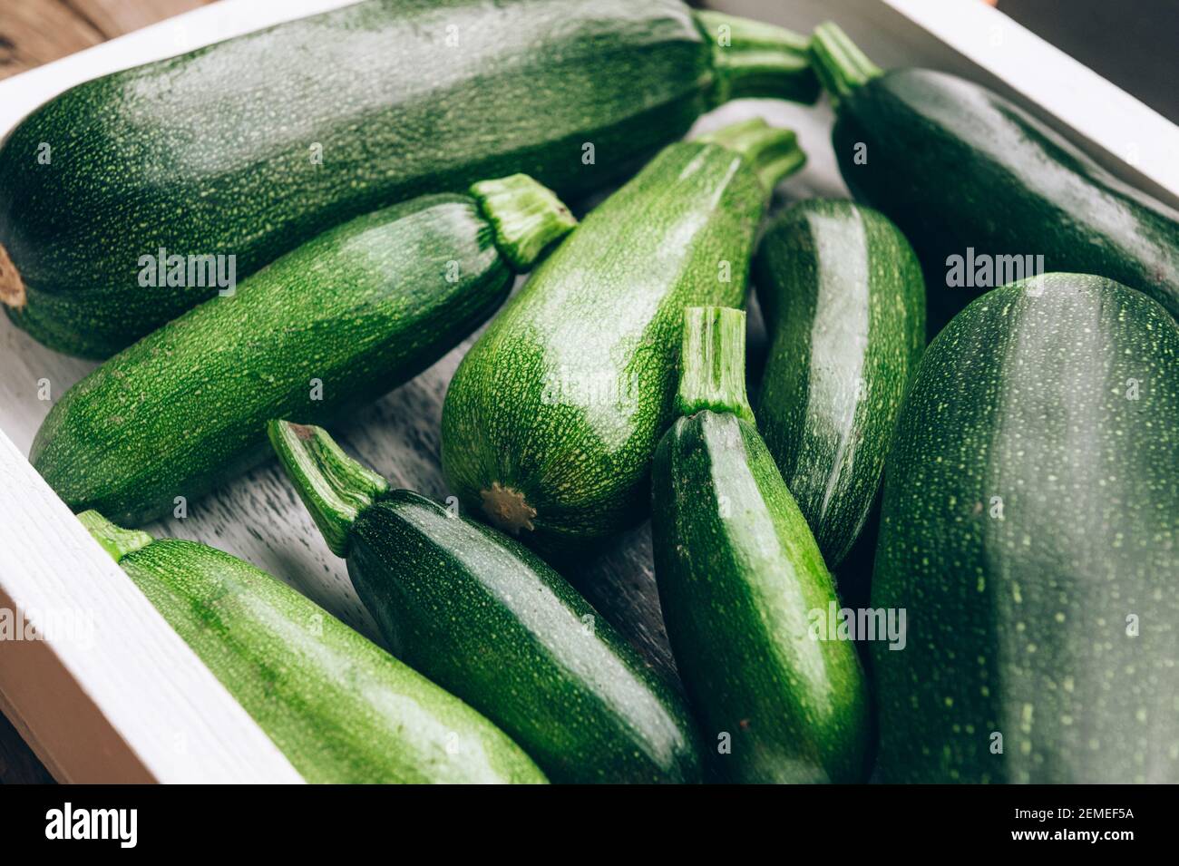 Fresh farmer organic zucchini on a wooden background Stock Photo - Alamy