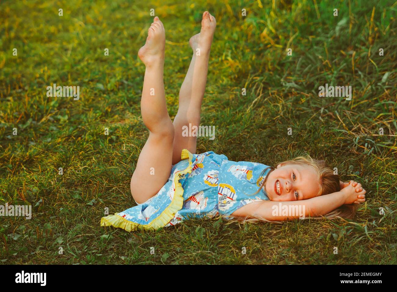 little girl resting on soft pillow in fresh spring grass Stock Photo ...