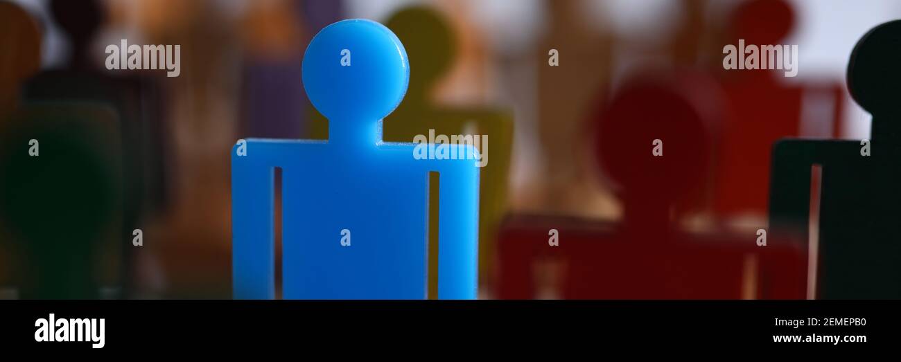 Blue plastic human figure stand out from many plastic dark figures of ...