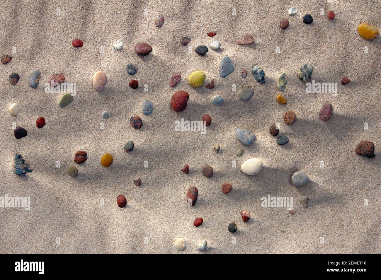 Still life image about colorful round pebbles, marbles on beach sand ...