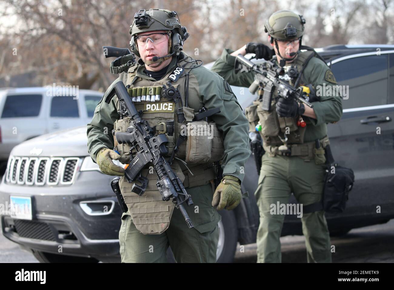 Police officers armed with rifles stage near a commercial building ...