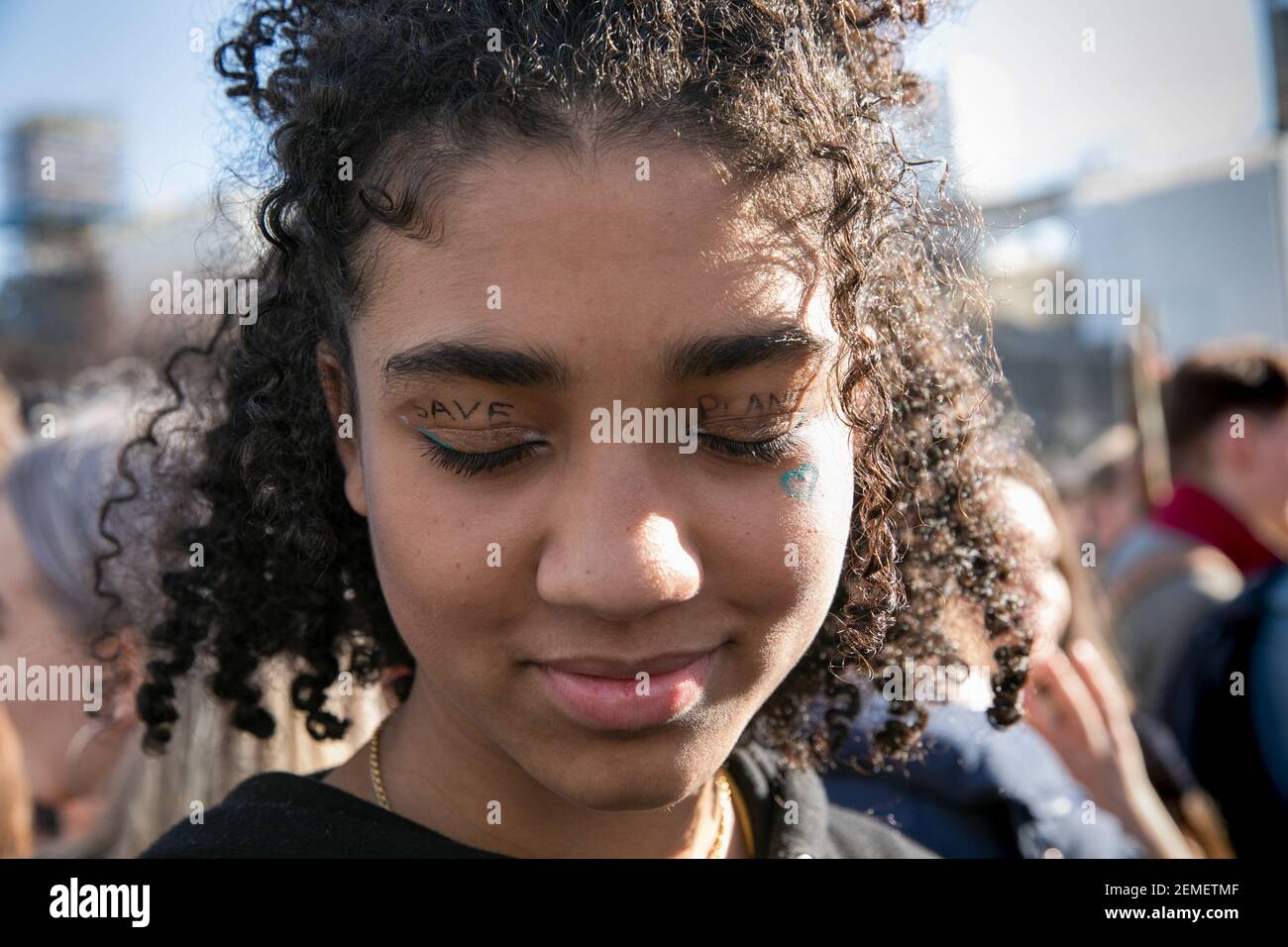 The eyes of a female climate protestor display the words 'Save' and ...