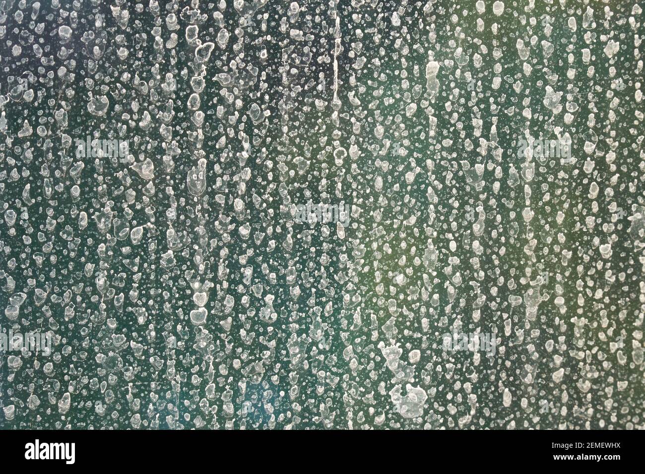 Rain water drops on window glass turned into limescale; color photo ...