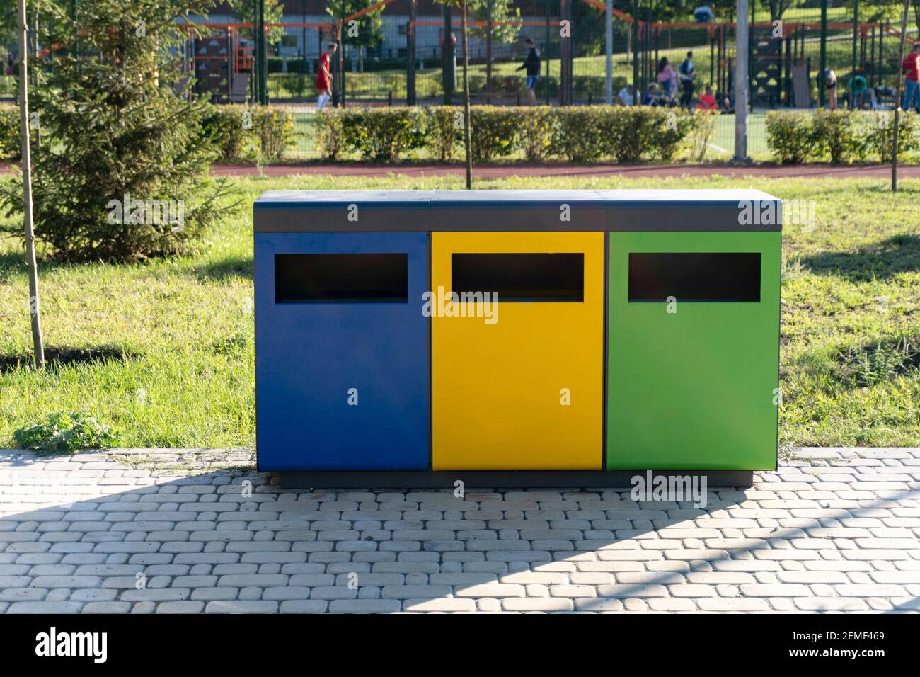 Three colorful recycle bins at urban environment Stock Photo - Alamy