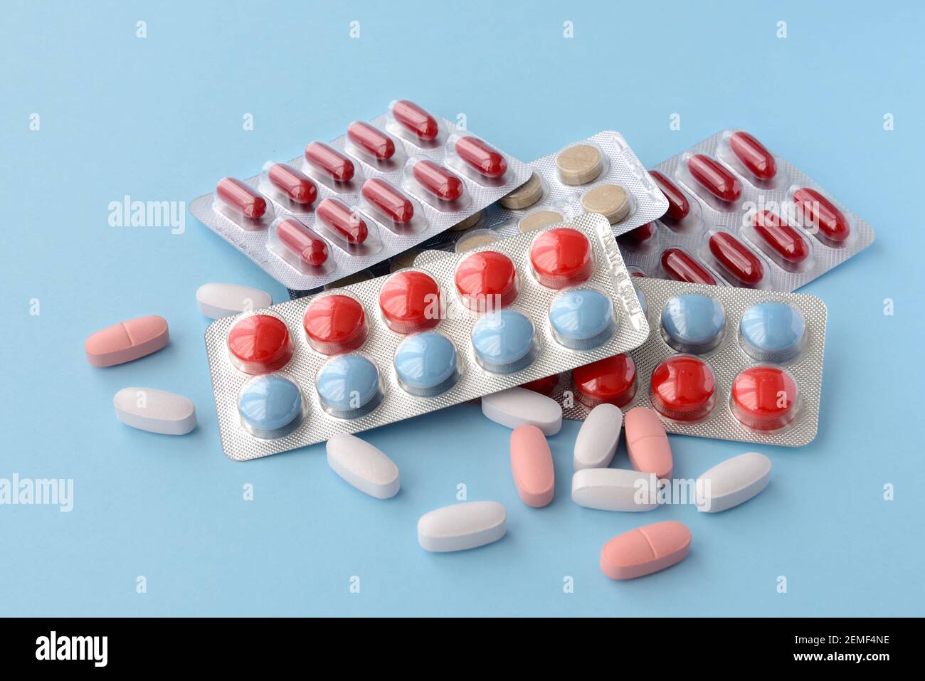 Assorted pharmaceutical medicine pills, tablets and capsules over blue ...