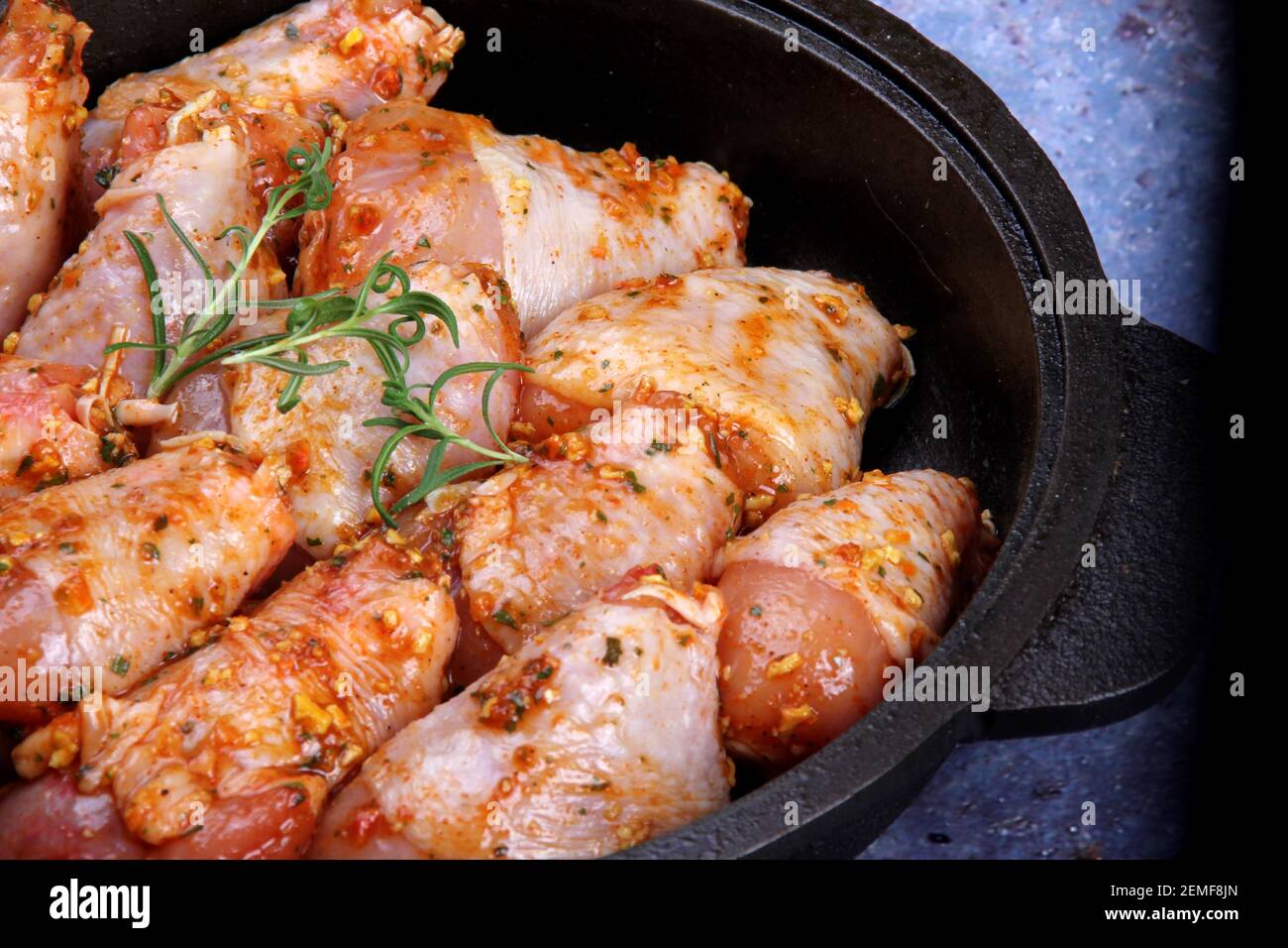 Marinated raw chicken legs on black pan. Uncooked marinated chicken ...