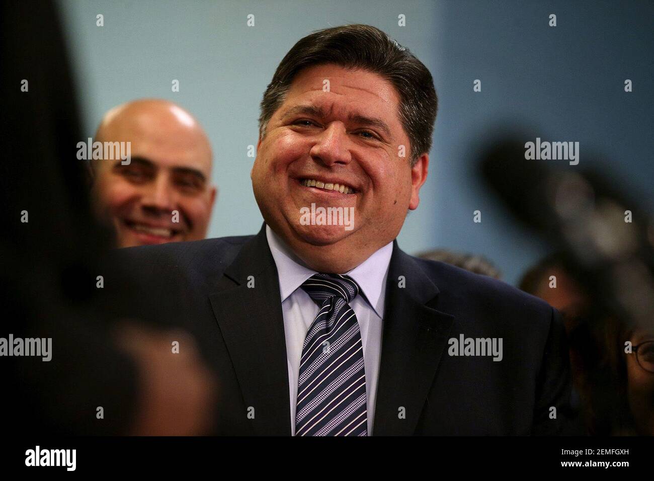 Gov. J.B. Pritzker listens to speakers at Young Elementary School in ...