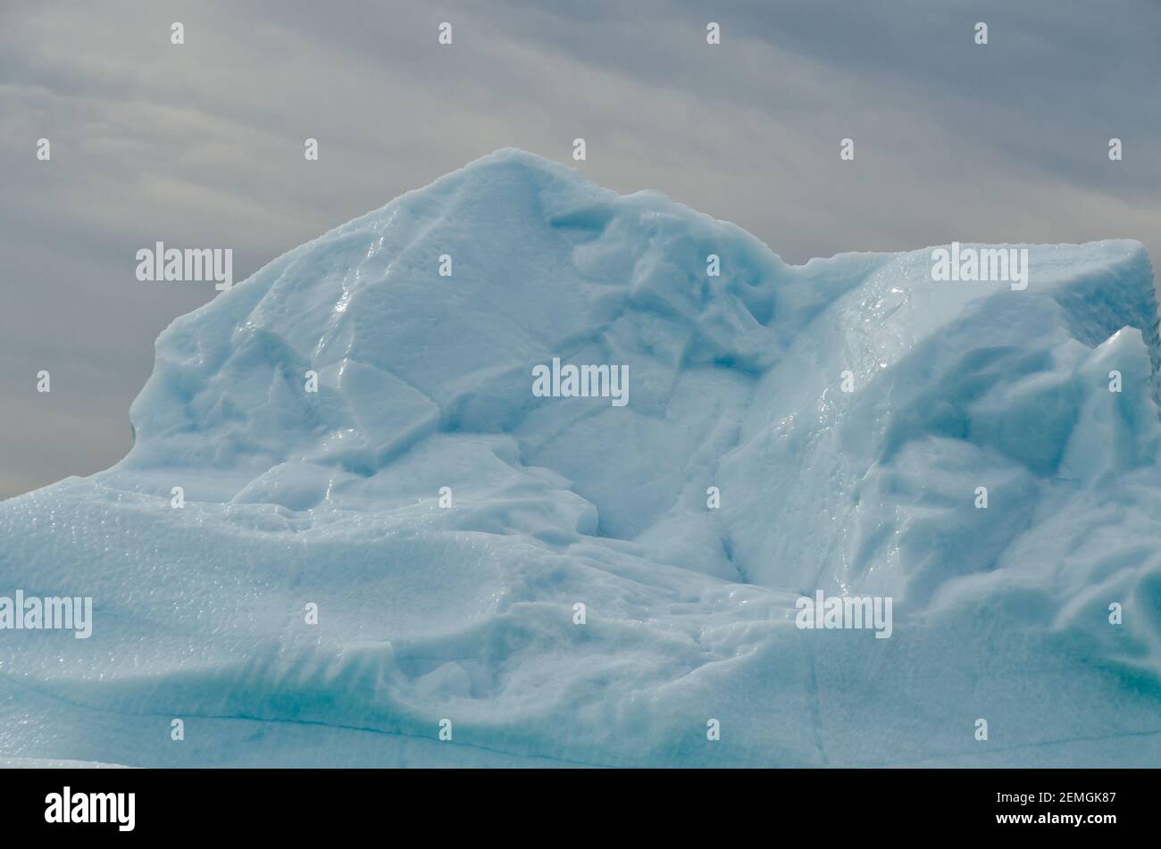 Bright white iceberg on dark water and rock background Stock Photo - Alamy