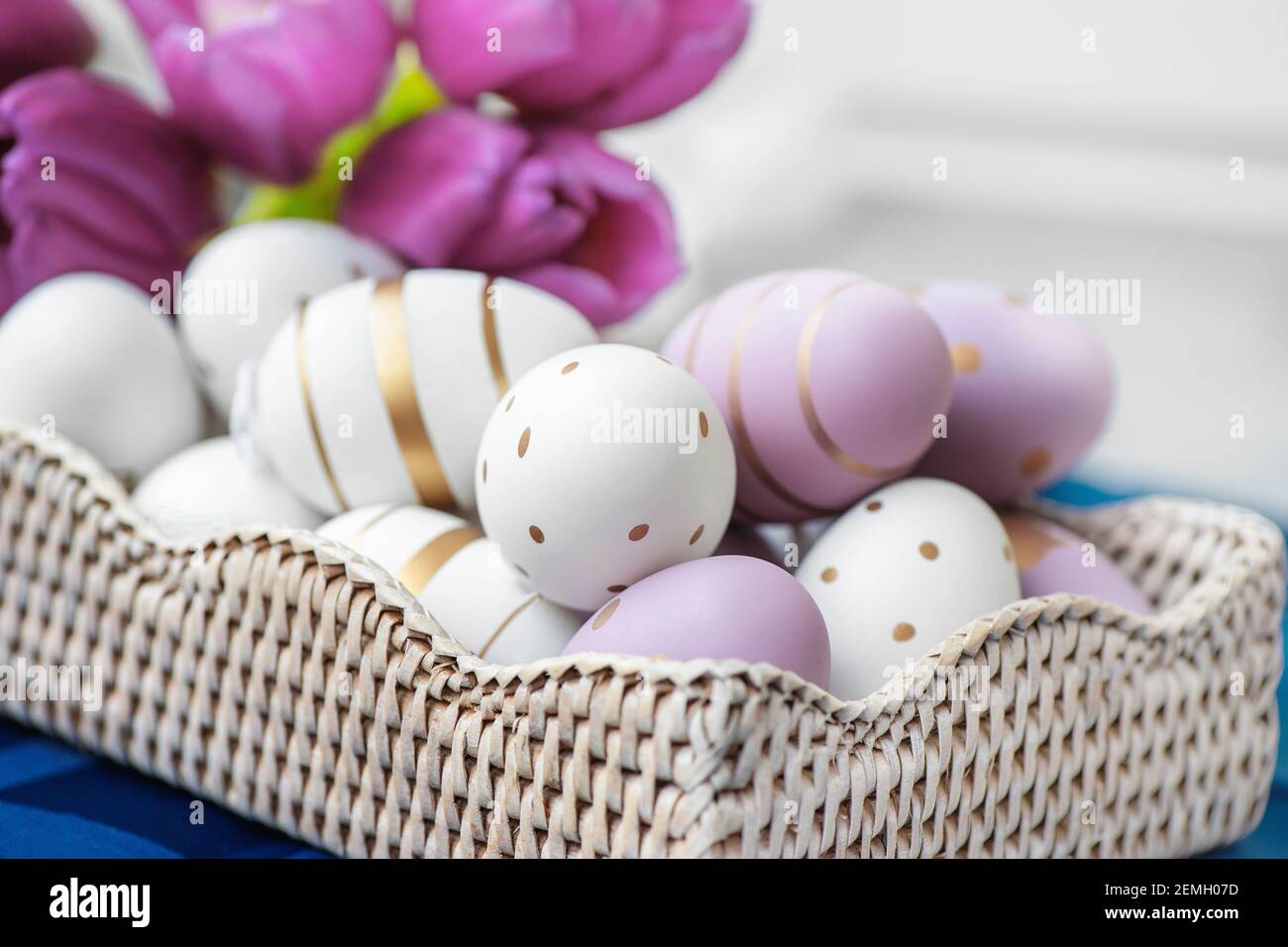 Pastel lilac Easter eggs in a wicker basket. Easter decoration in ...