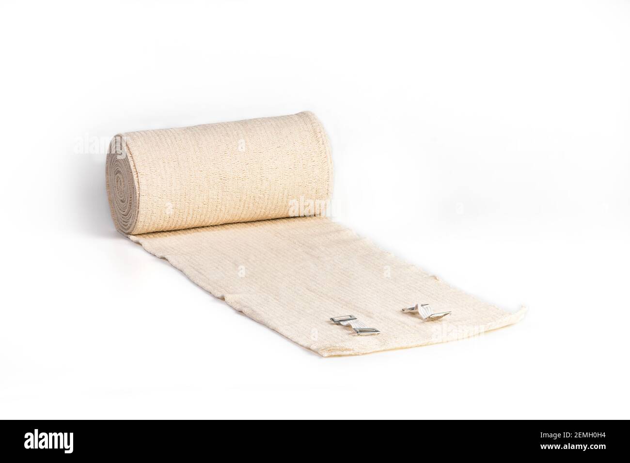 Woven elastic medical bandage rolled into roll and fixation clips on a ...